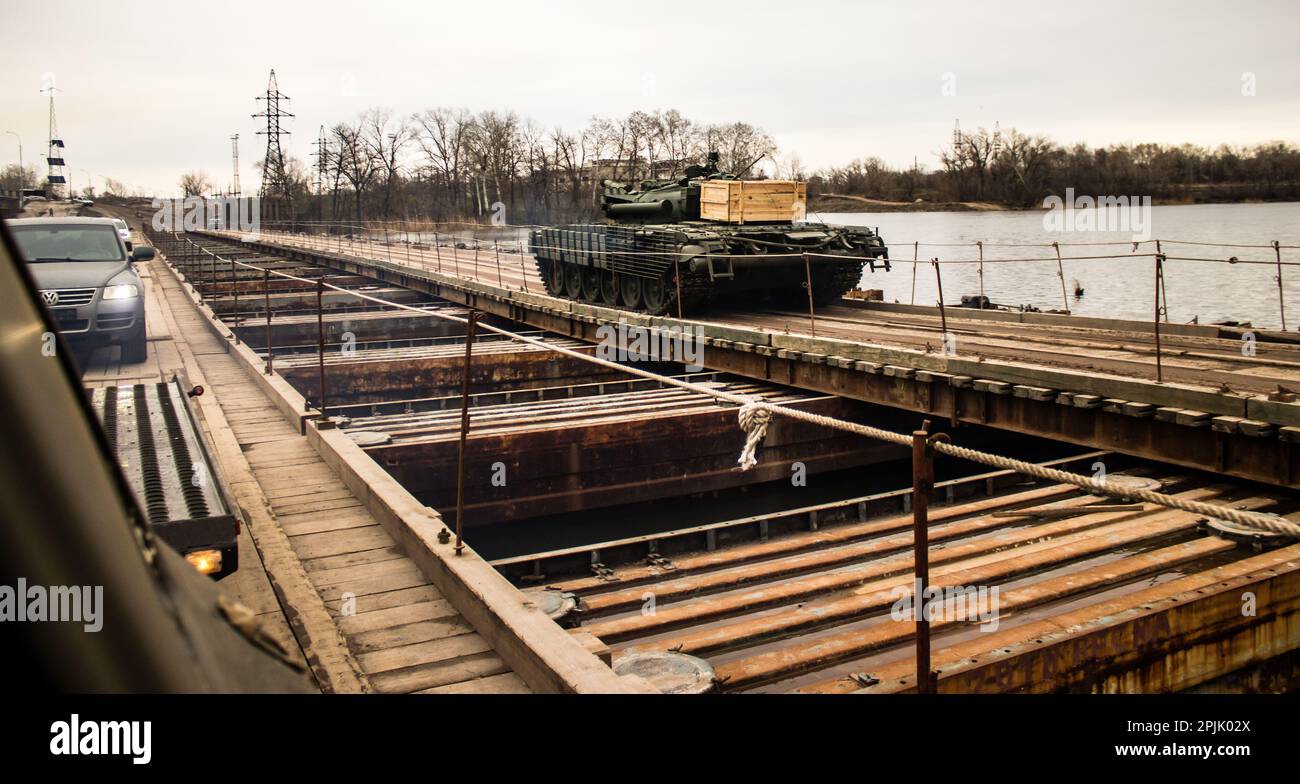 Ukrainian T-72B tank crossing a pontoon bridge rising to the front line ...