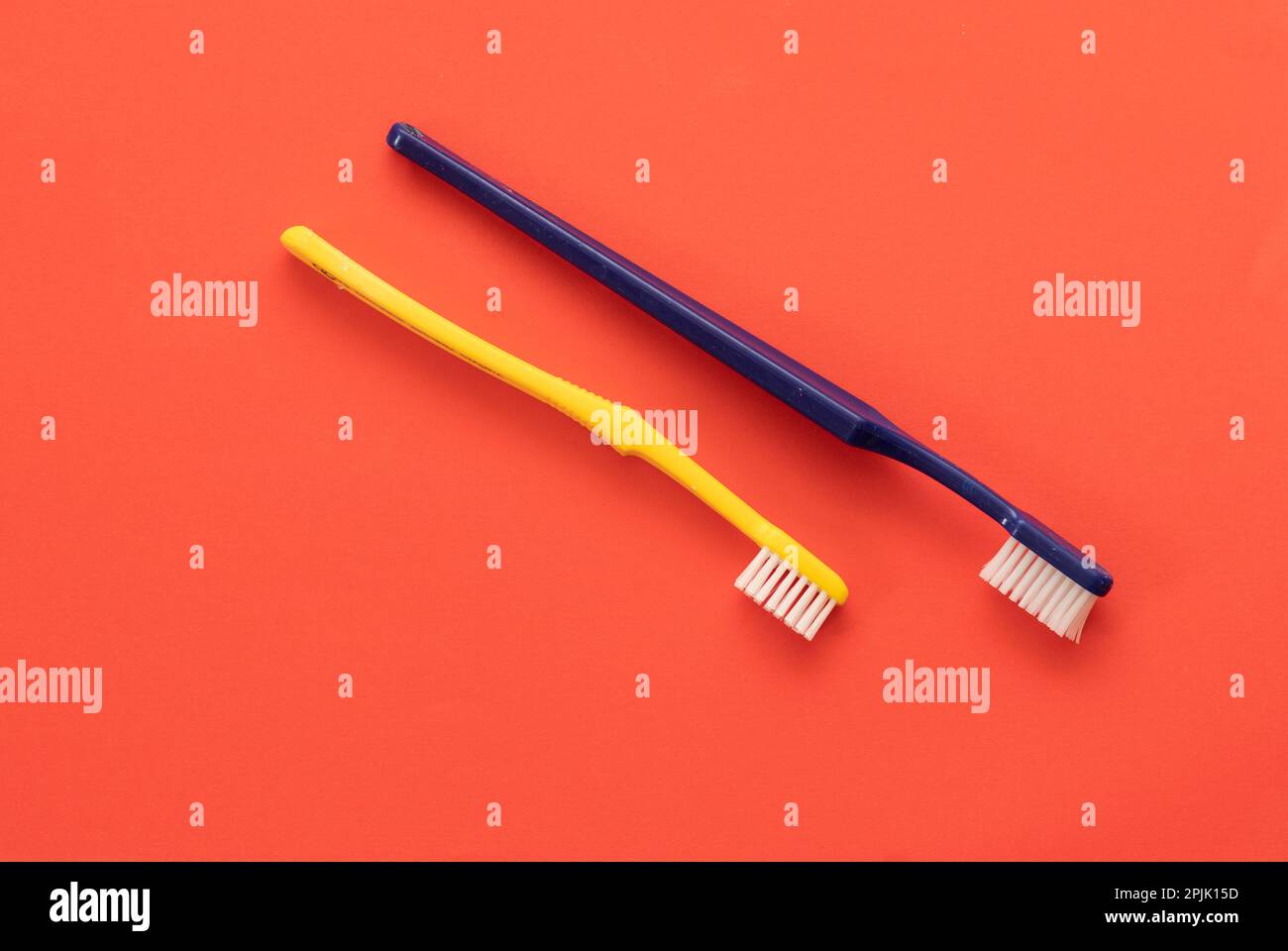 Toothbrushes in different colors on a red background Stock Photo - Alamy