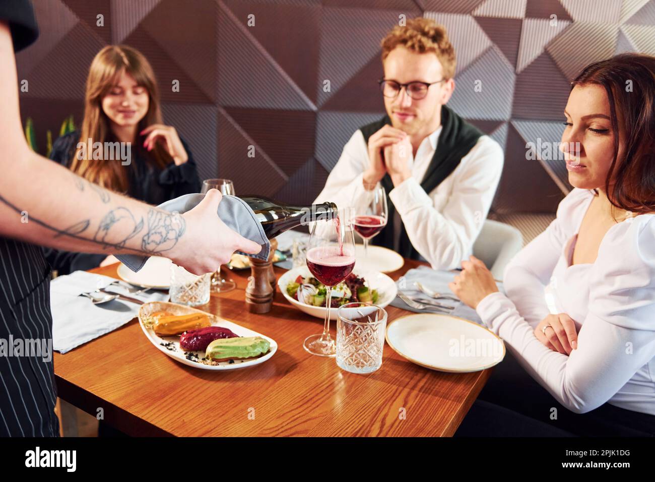 People have a dinner together. Indoors of new modern luxury restaurant ...