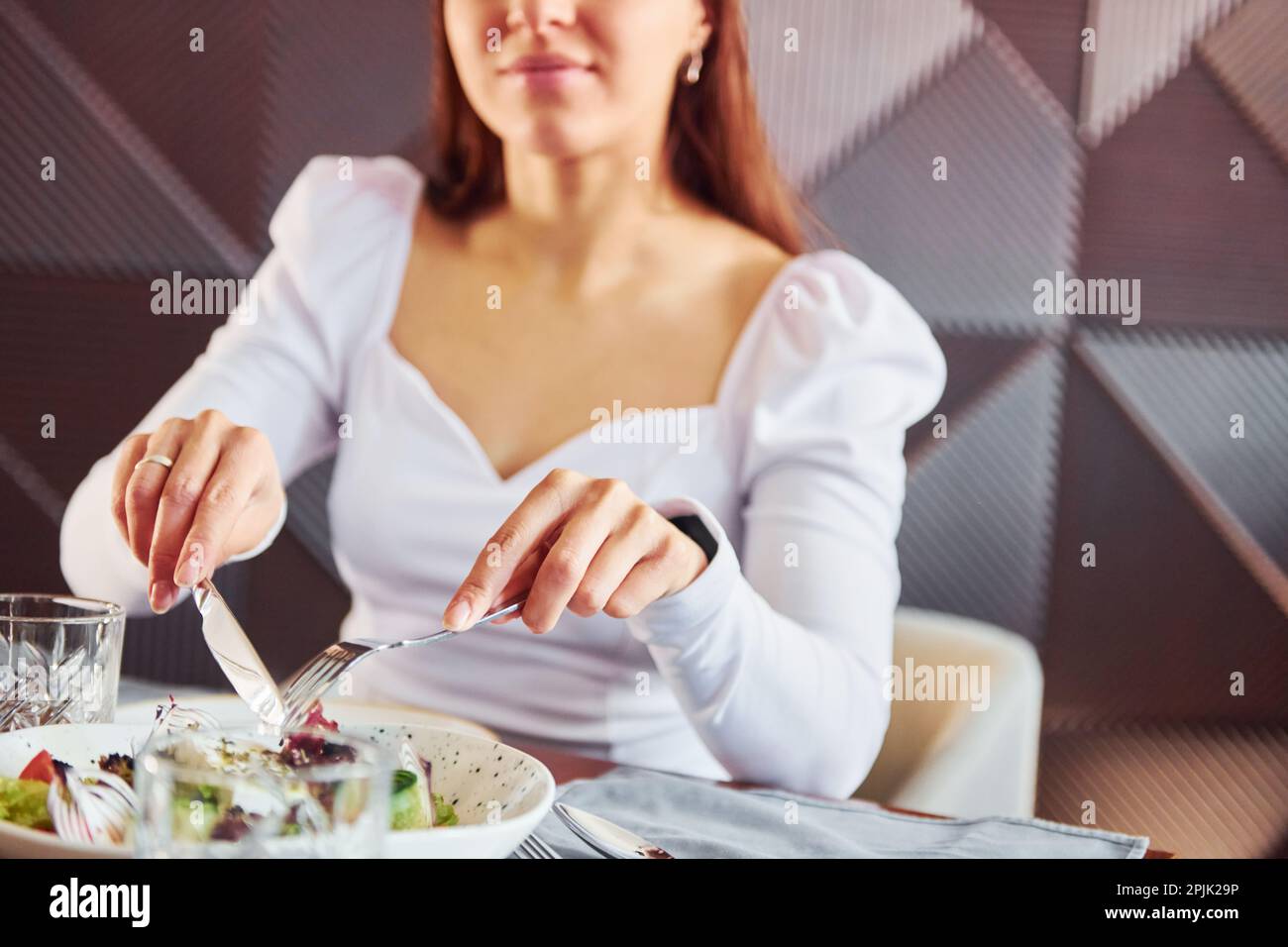 Beautiful woman sits by table. Indoors of new modern luxury restaurant ...
