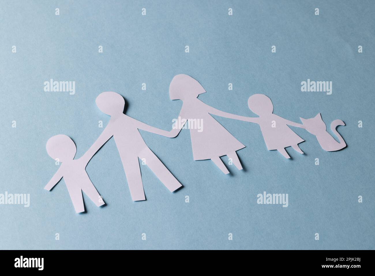 White paper cut out of family with two children and cat and copy space ...