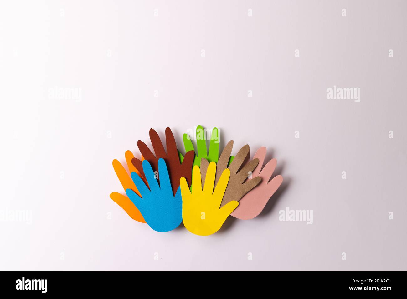Close up of paper cut out of multi coloured hands with copy space on ...