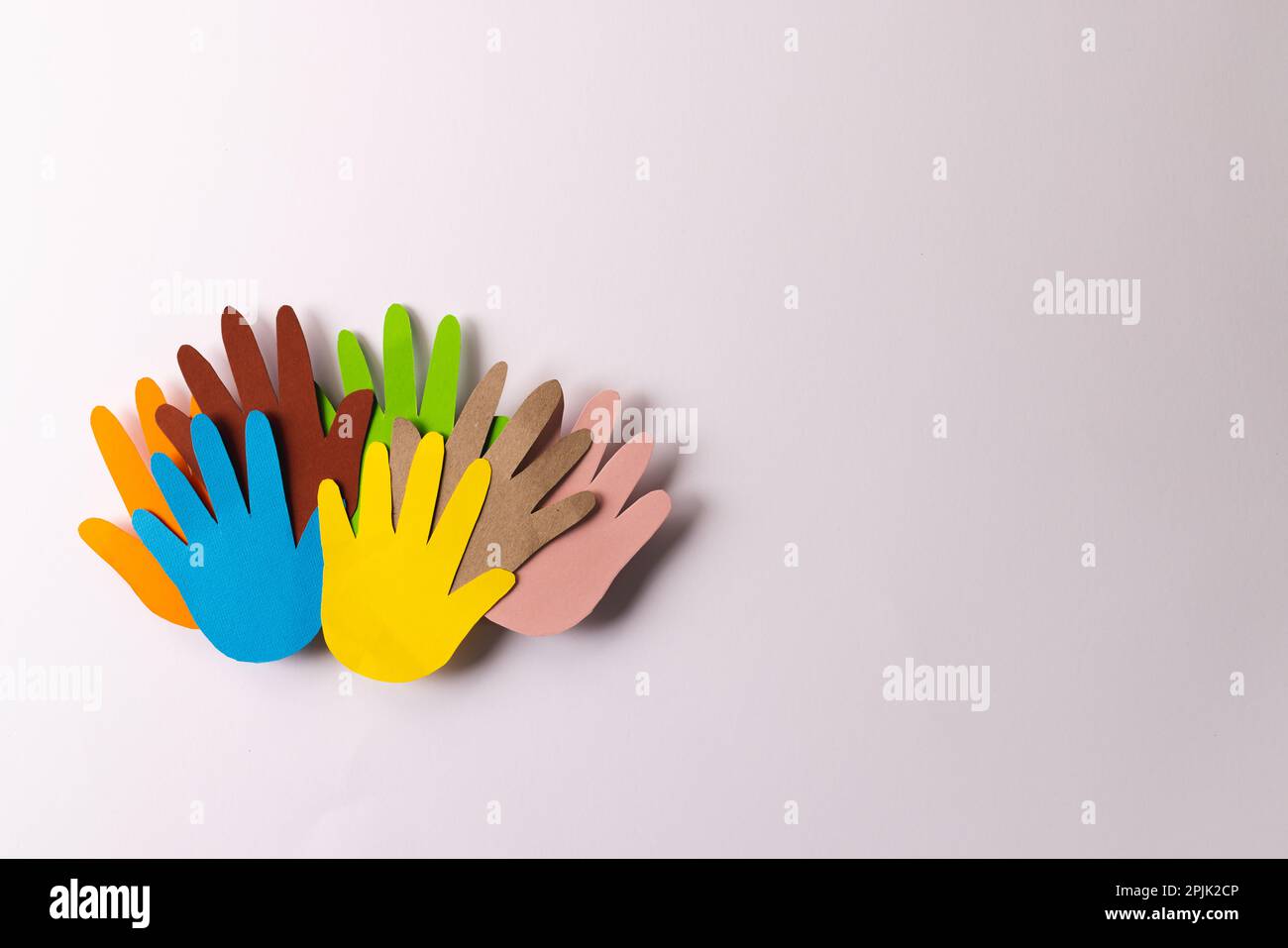 Close up of paper cut out of multi coloured hands with copy space on ...