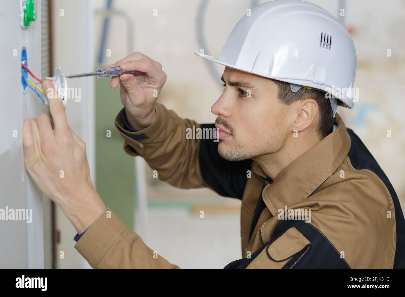 he is installing electricity socket Stock Photo - Alamy