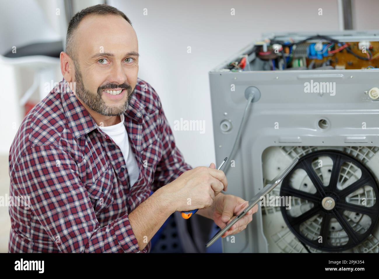 working man repairs a washing machine in laundry Stock Photo - Alamy