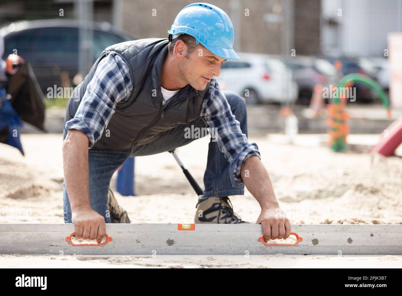 male construction worker levelling sand Stock Photo - Alamy