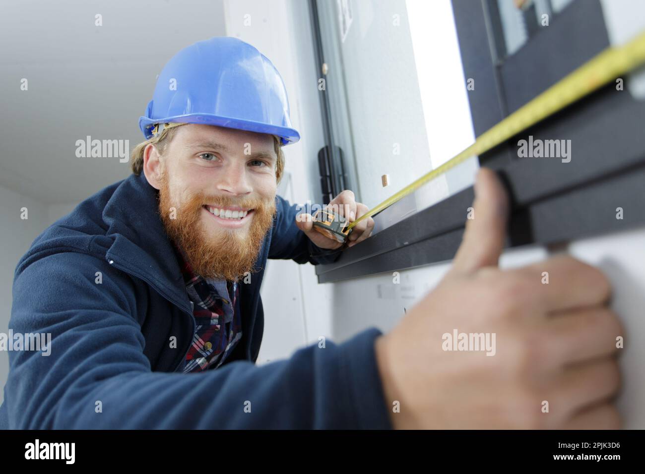 male worker taking measurements of window in flat Stock Photo - Alamy