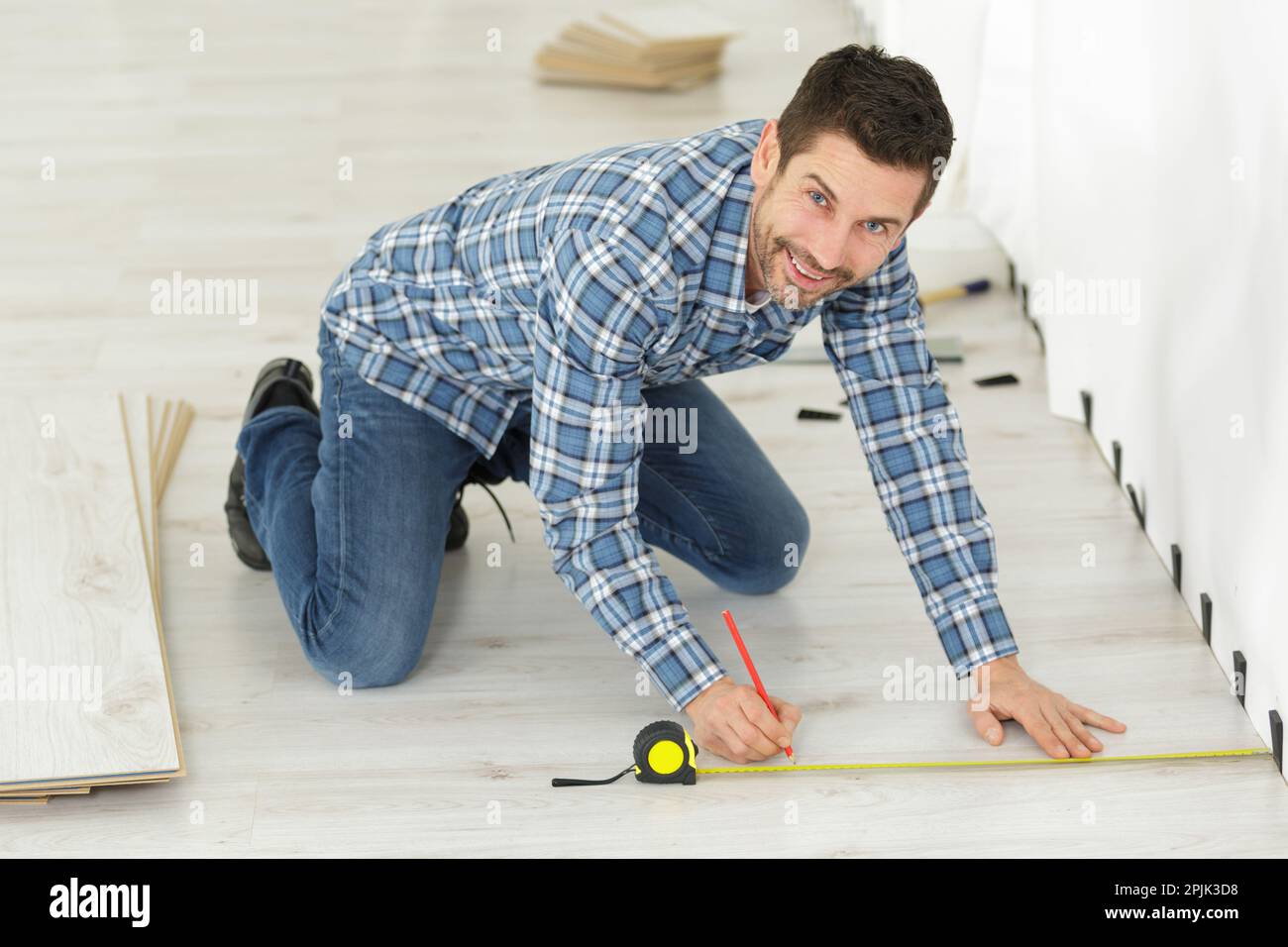 a man measuring floor board Stock Photo - Alamy