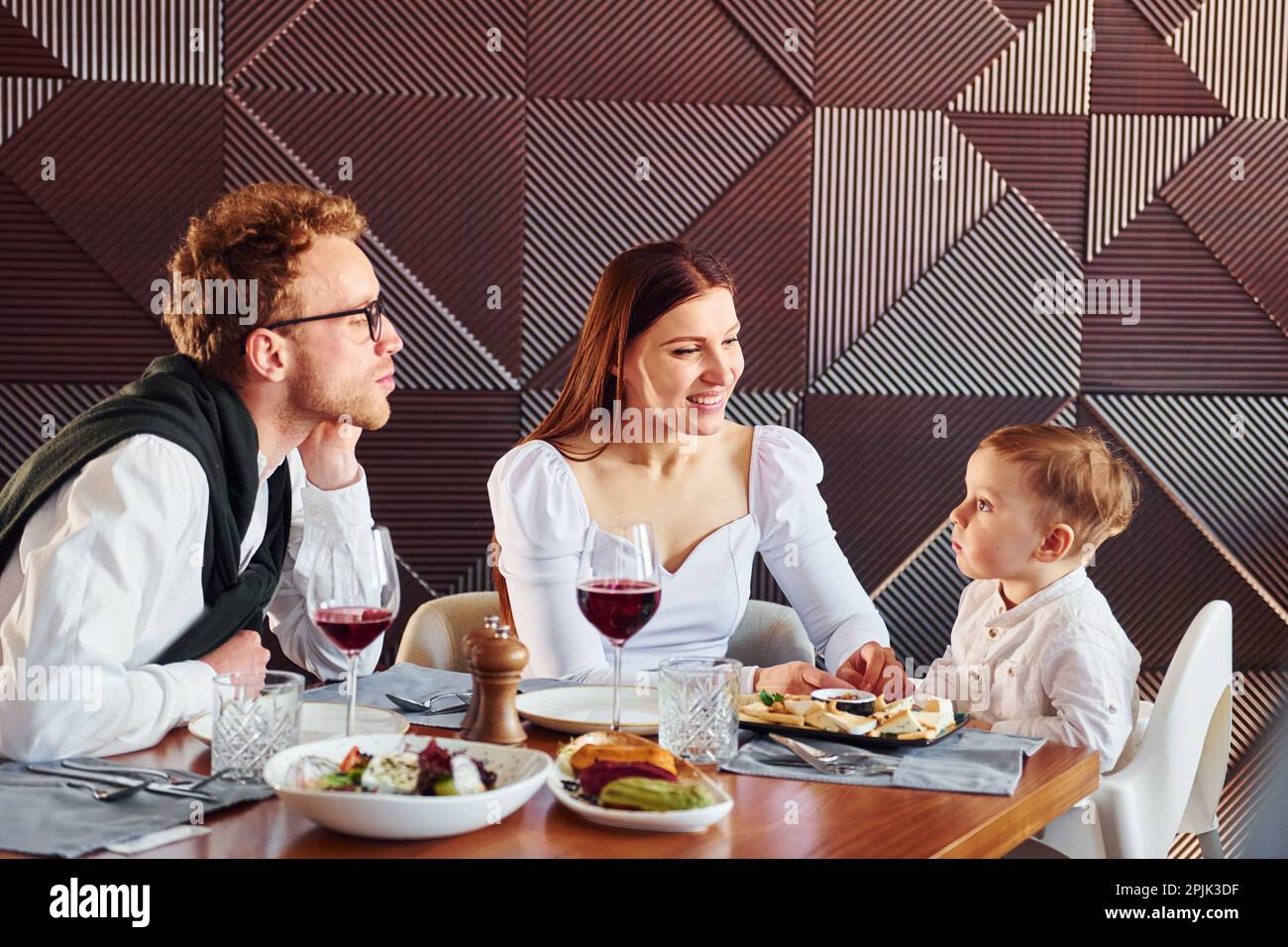 Young guy, woman and little boy. Indoors of new modern luxury ...