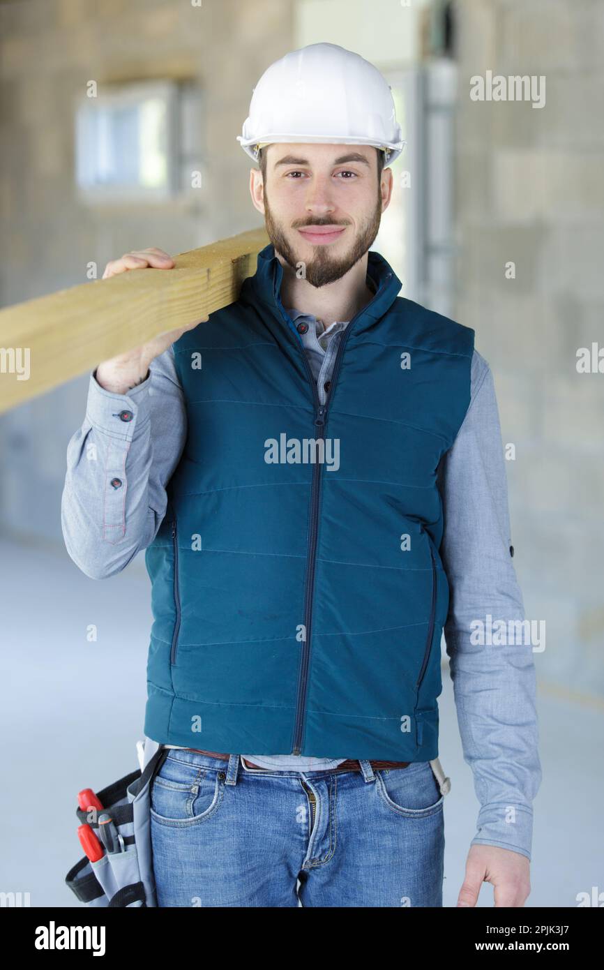 man as builder carrying wood and working Stock Photo - Alamy