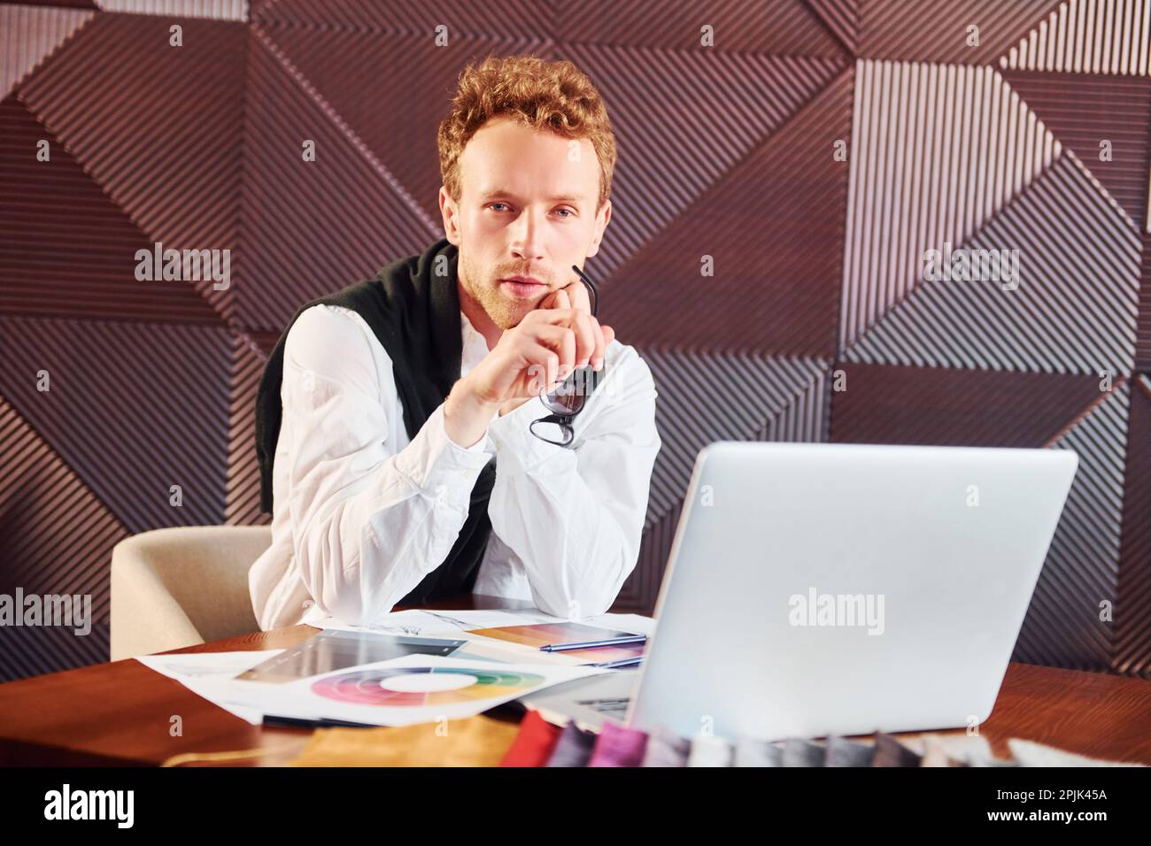 Man sits by table with laptop. Indoors of new modern luxury restaurant ...