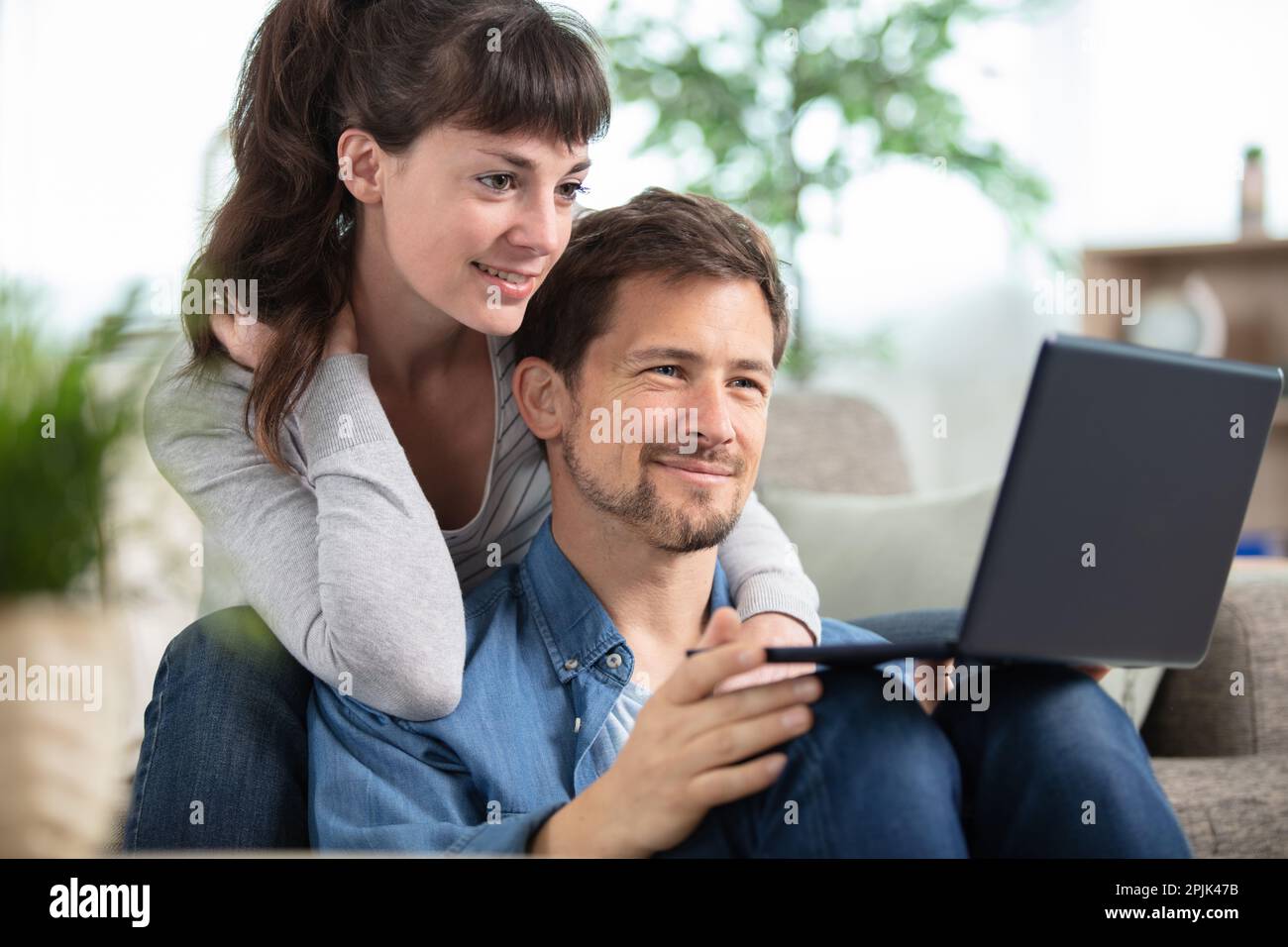 happy millennial couple sit relax on couch in living room Stock Photo ...