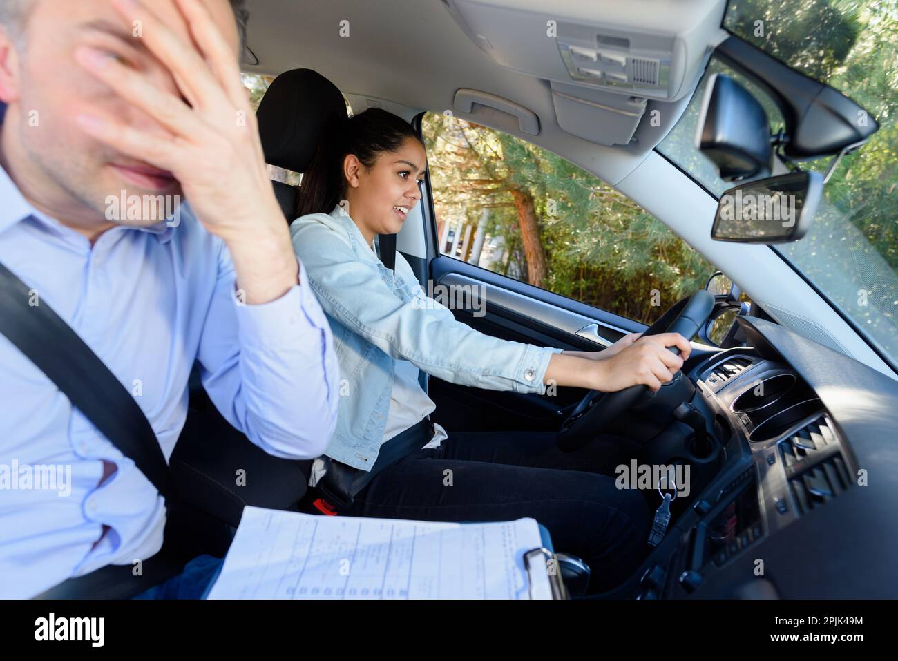 fearful driving instructor with female learner driver Stock Photo - Alamy