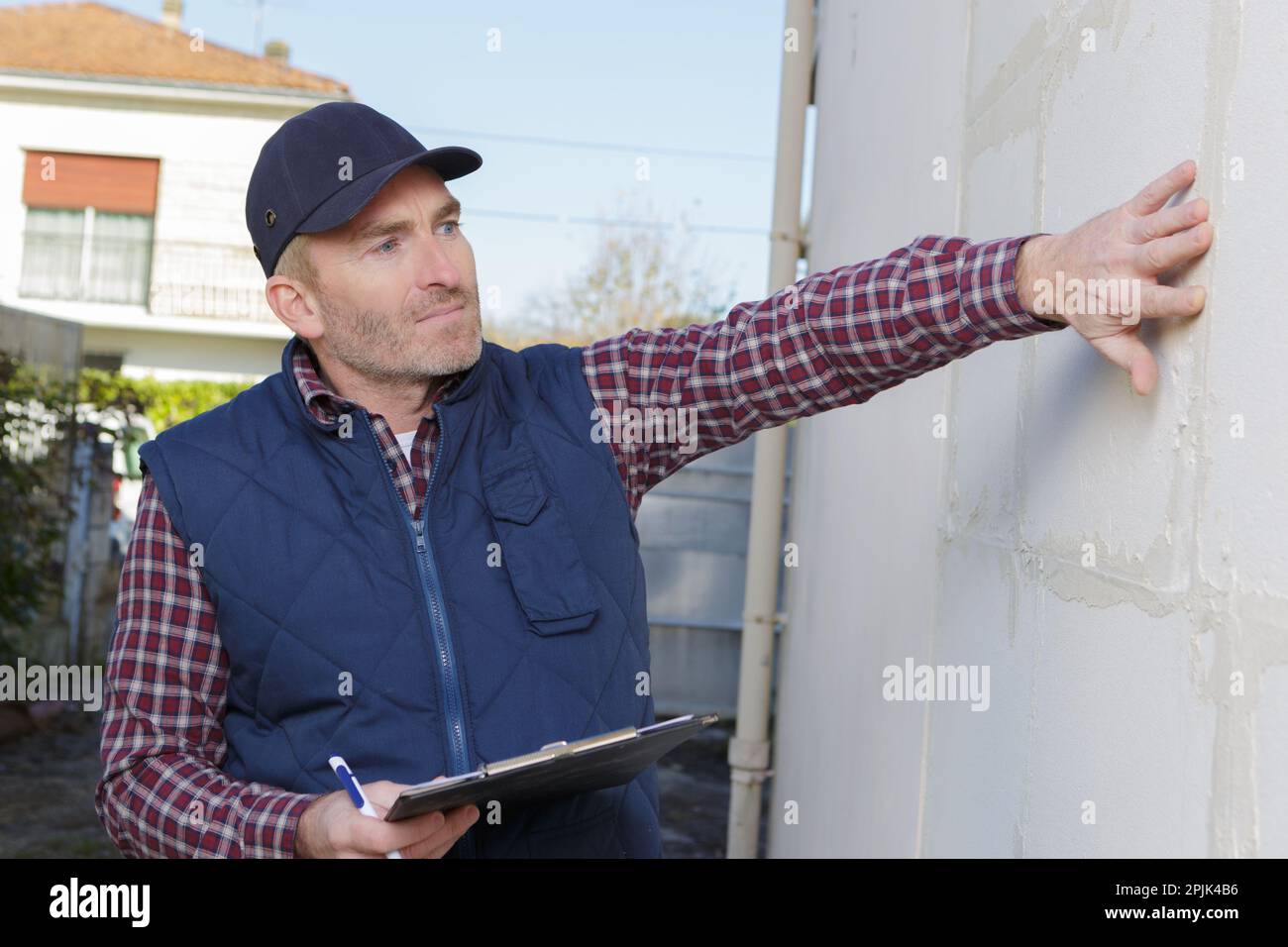 construction worker checking house wall Stock Photo - Alamy