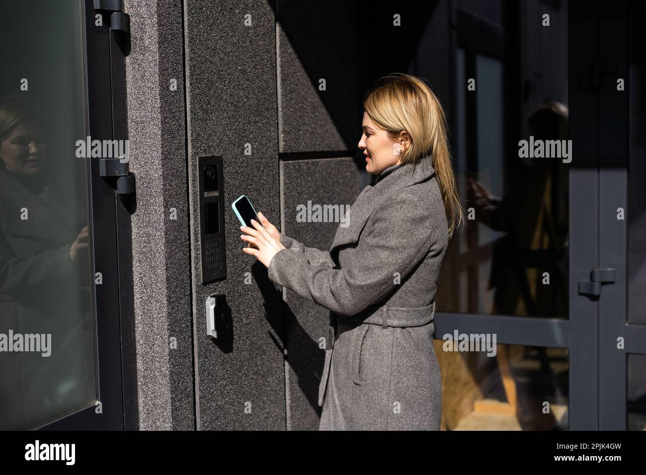 Smart home concept - close up of woman use mobile phone to open ...