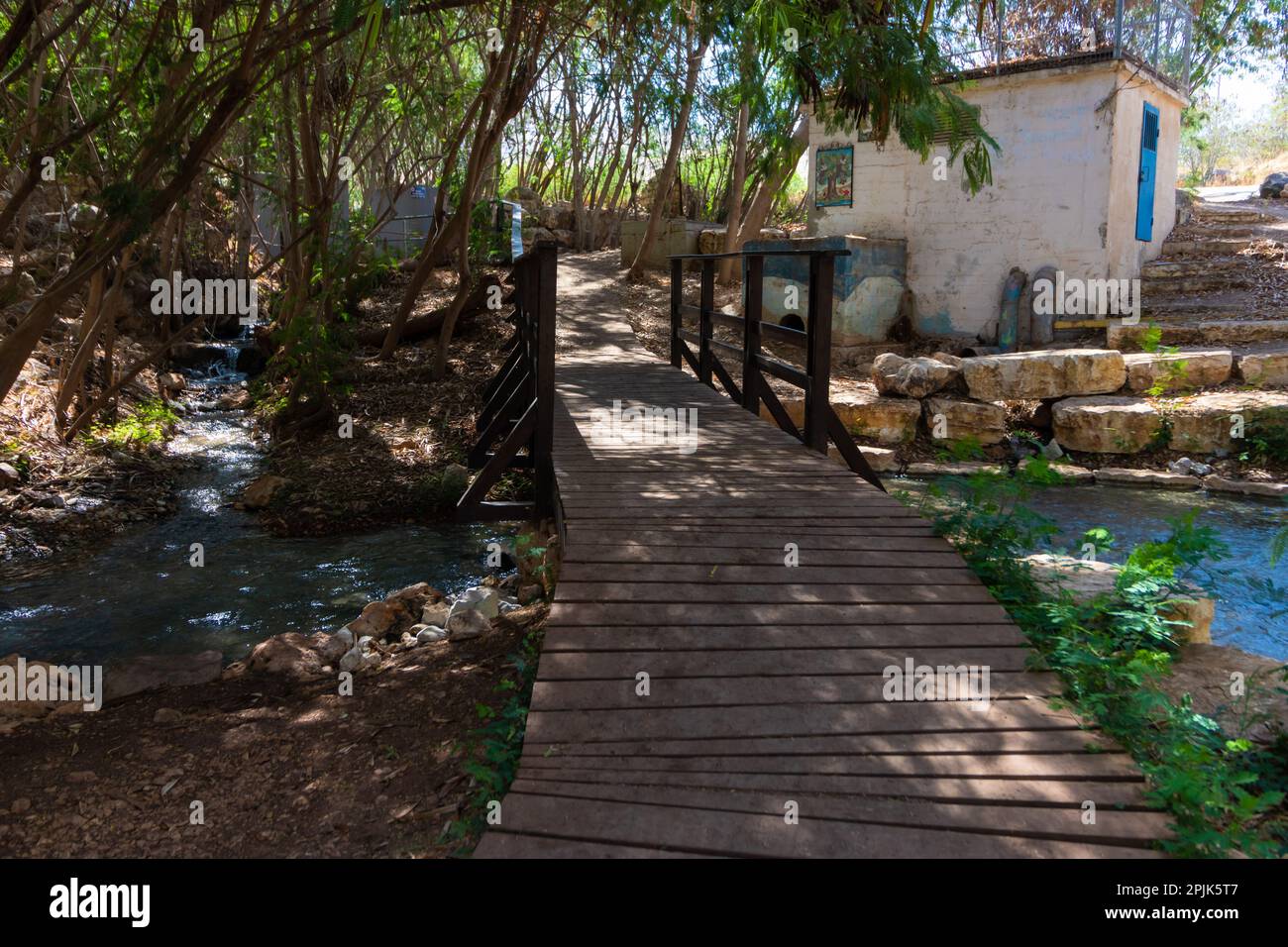 A small wooden bridge, over the flowing water of the Shokek River, the ...