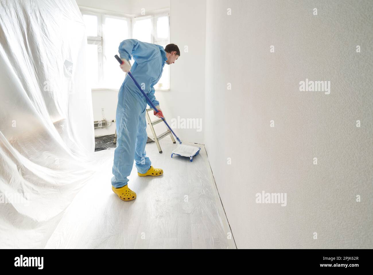 Man dipping a roller into a palette of paint. Concept of home makeover ...