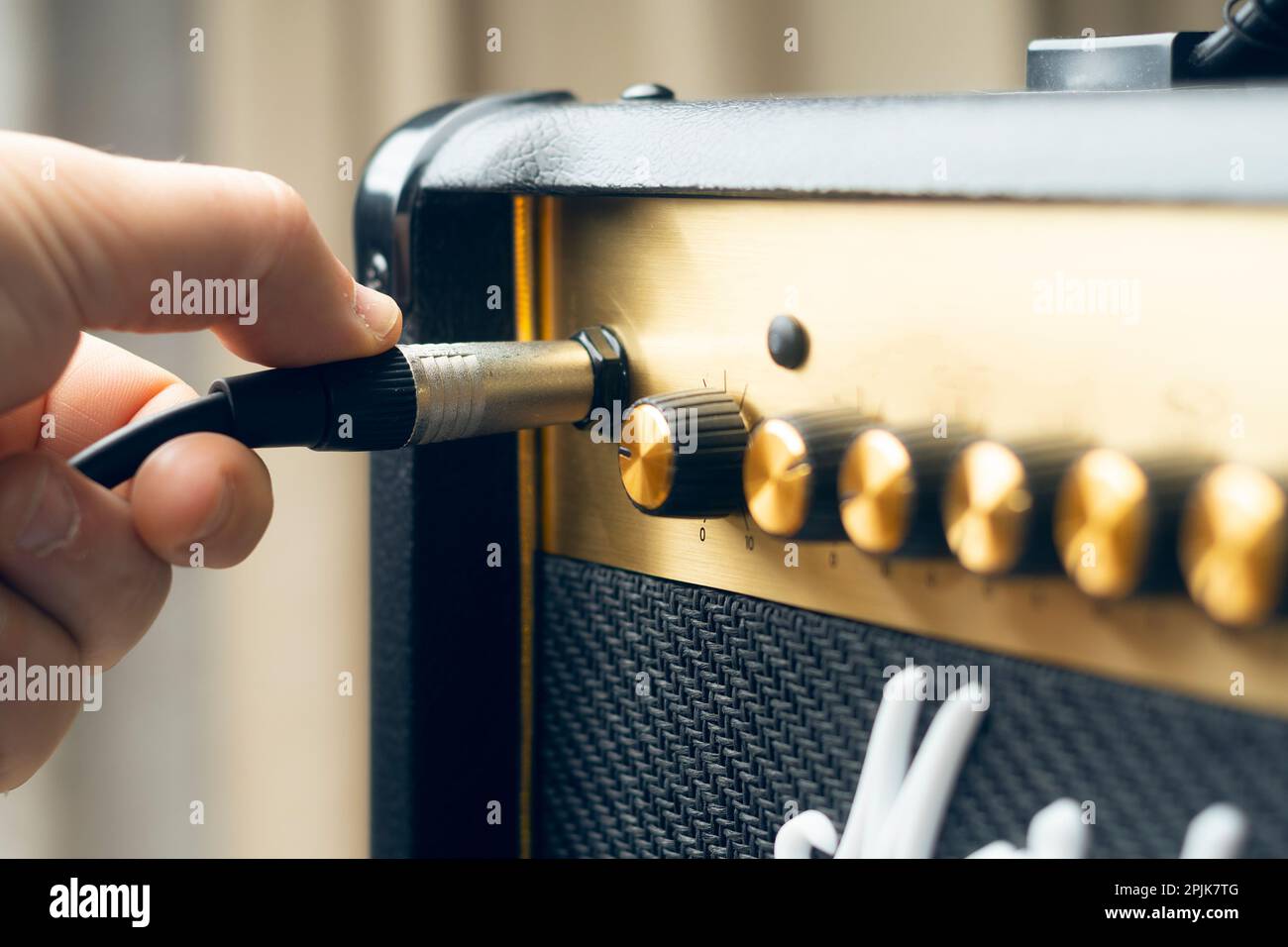 Man plug a jack into a guitar amplifier, shallow depth of field Stock ...