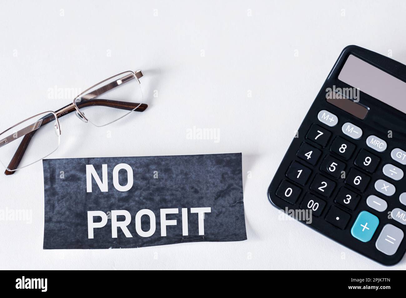 Office table with paper black sticker, glasses and calculator. Top text ...