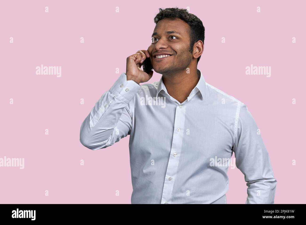 Portrait of excited indian man talking on his smartphone. Brown young ...