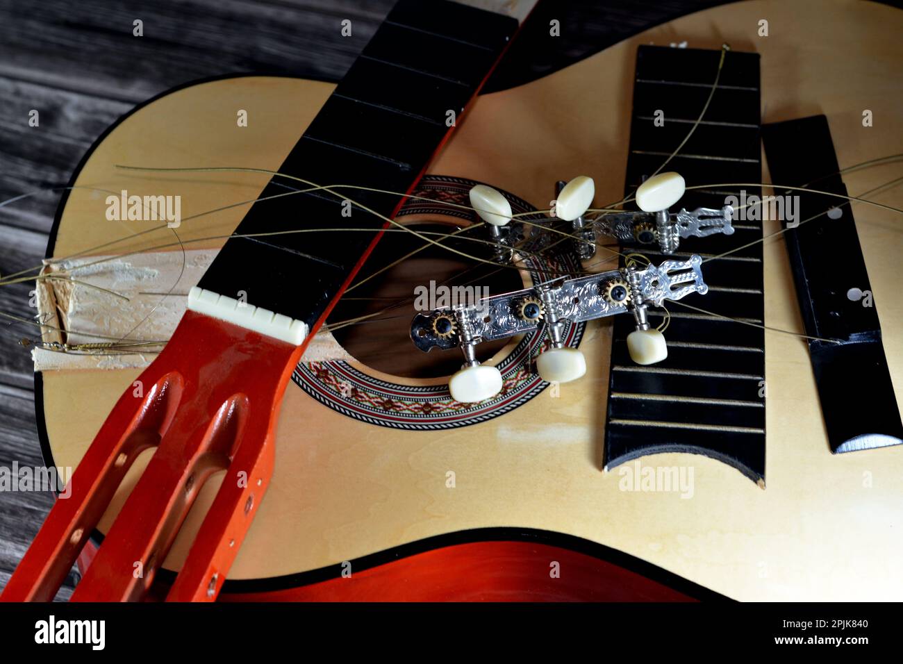 A broken wooden old classic guitar with damaged strings chords ...