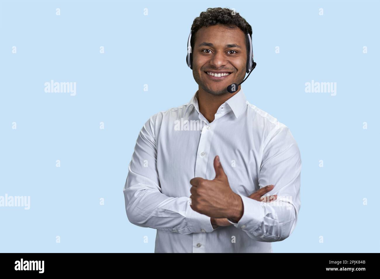 Portrait of a young smiling customer support worker. Indian man with ...