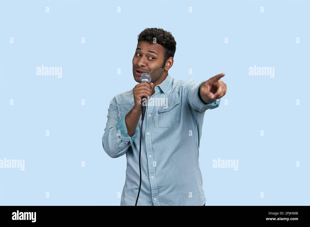 Portrait of an indian singer pointing at someone from audience ...