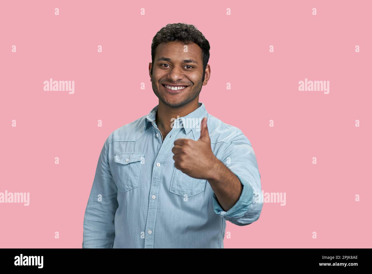 Young smiling south asian man showing a thumb up. Happy successful guy ...