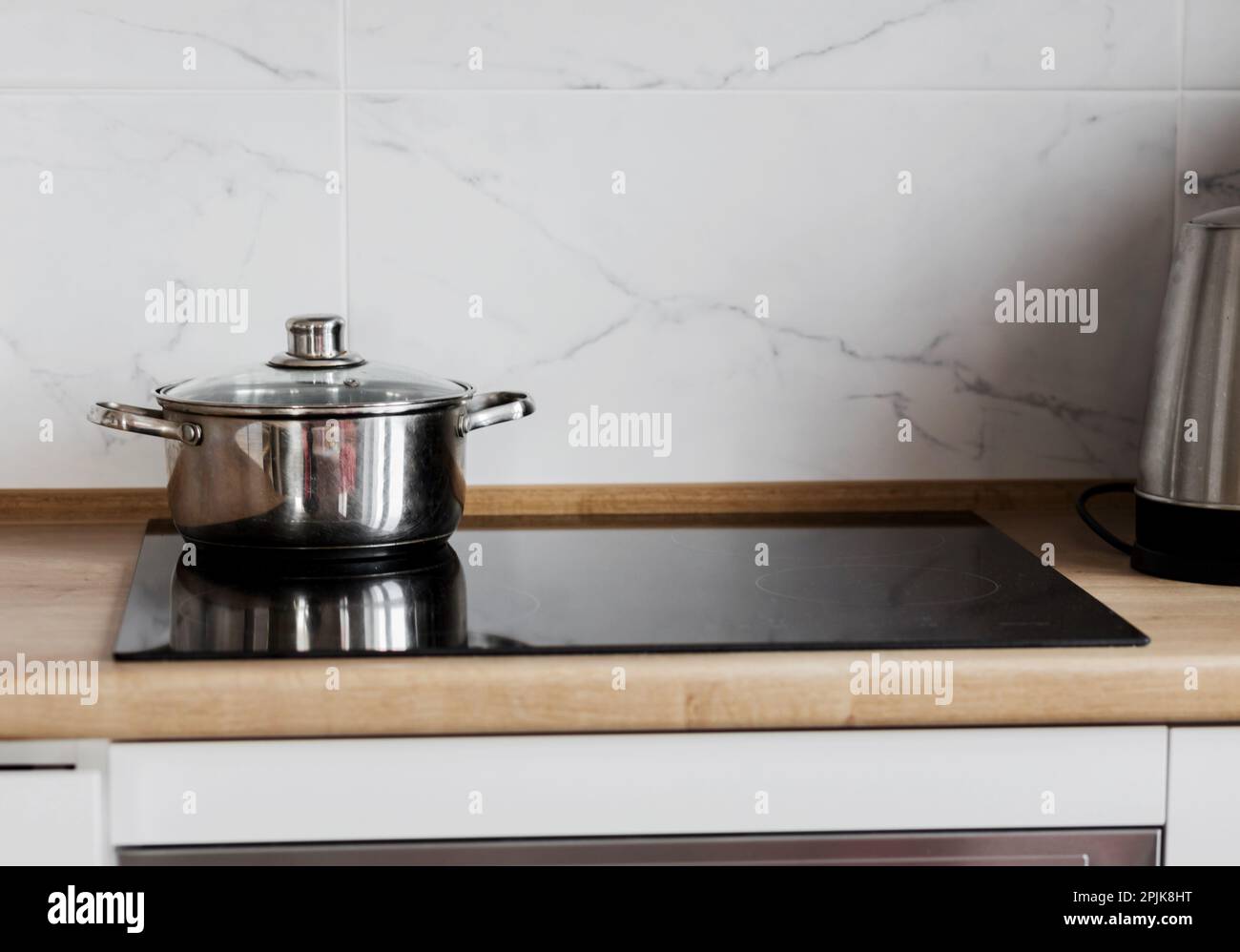 Black ceramic induction stove with metal pot. Contemporary home with ...