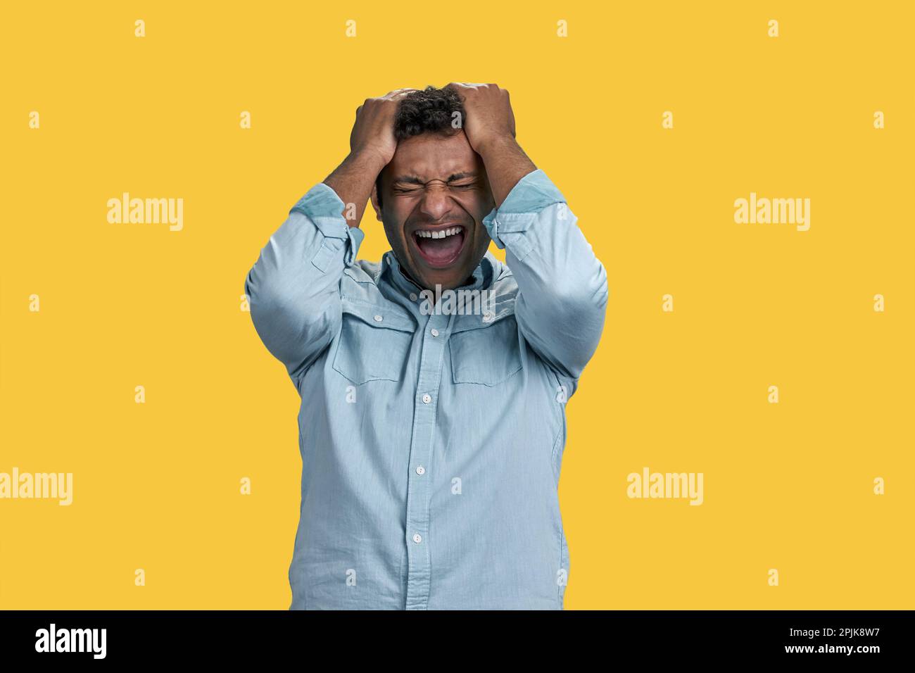 Young indian man yelling with aggressive expression and hands holding ...