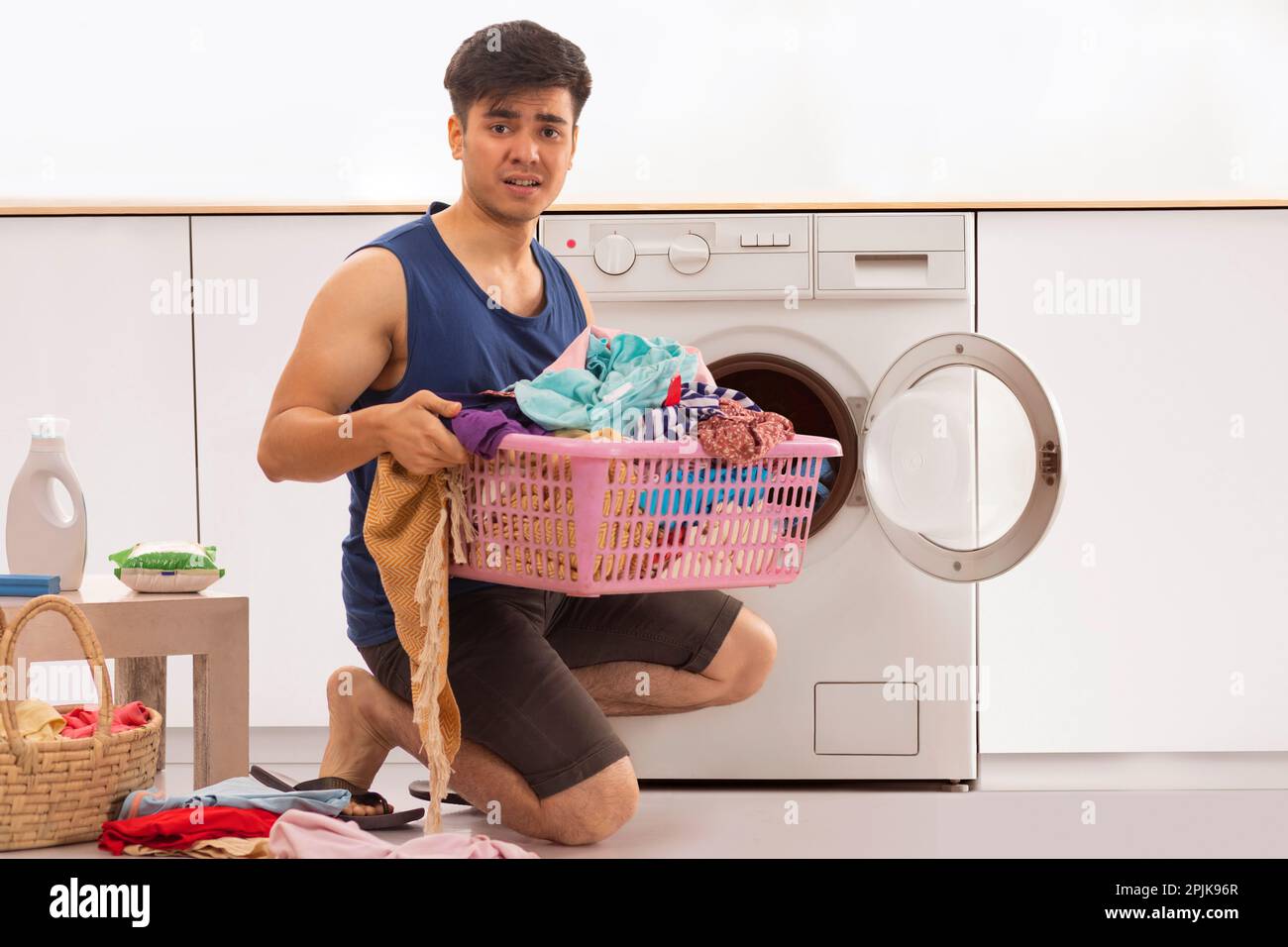 Man laundry basket kneeling hi-res stock photography and images - Alamy