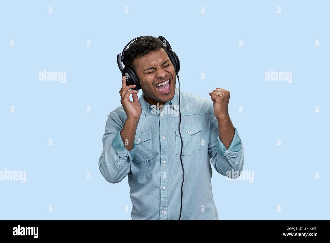 Portrait of excited emotional Indian man listen to music in headphones ...