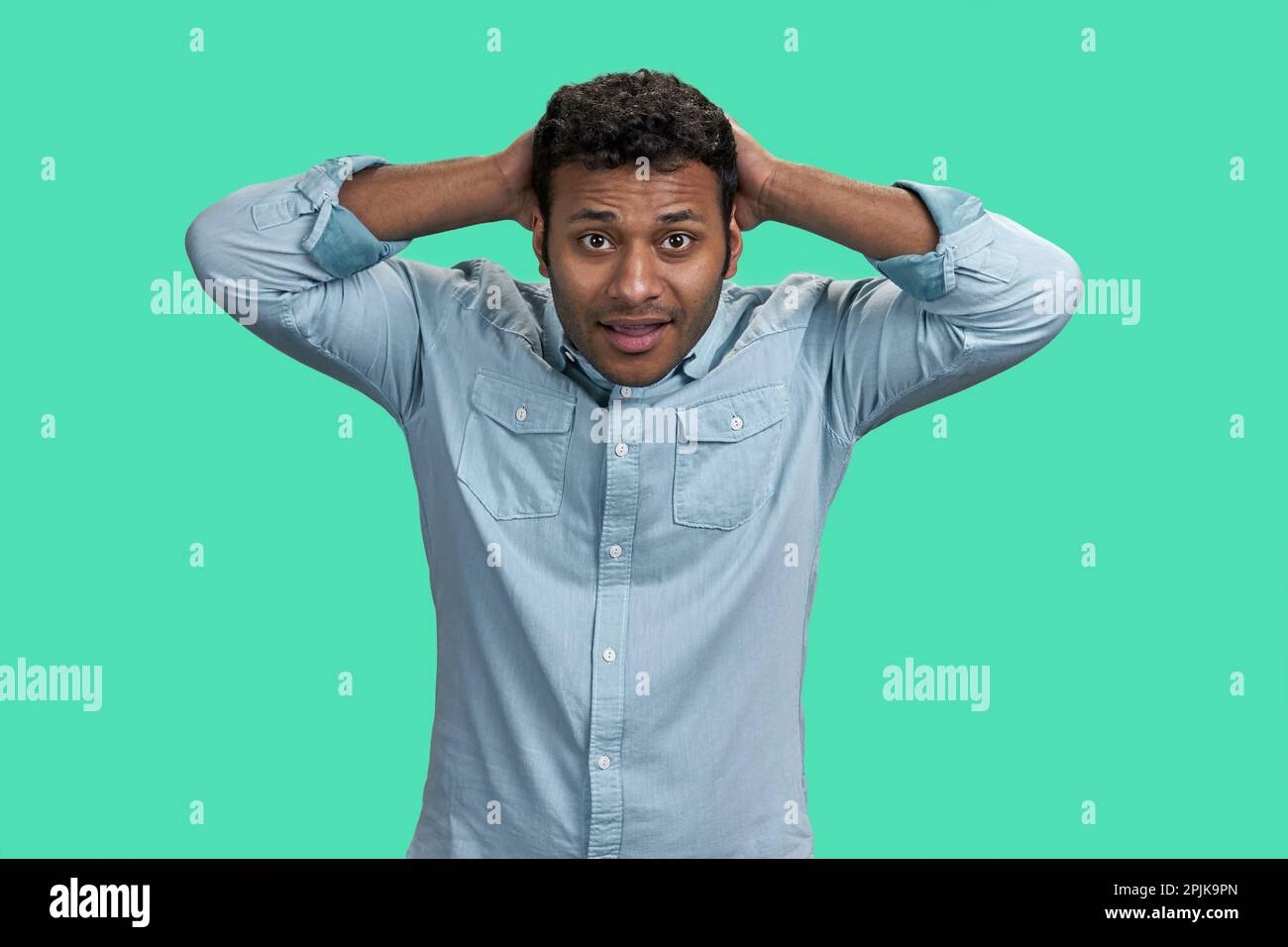 Portrait of shocked indian man touching his head. Isolated on green ...