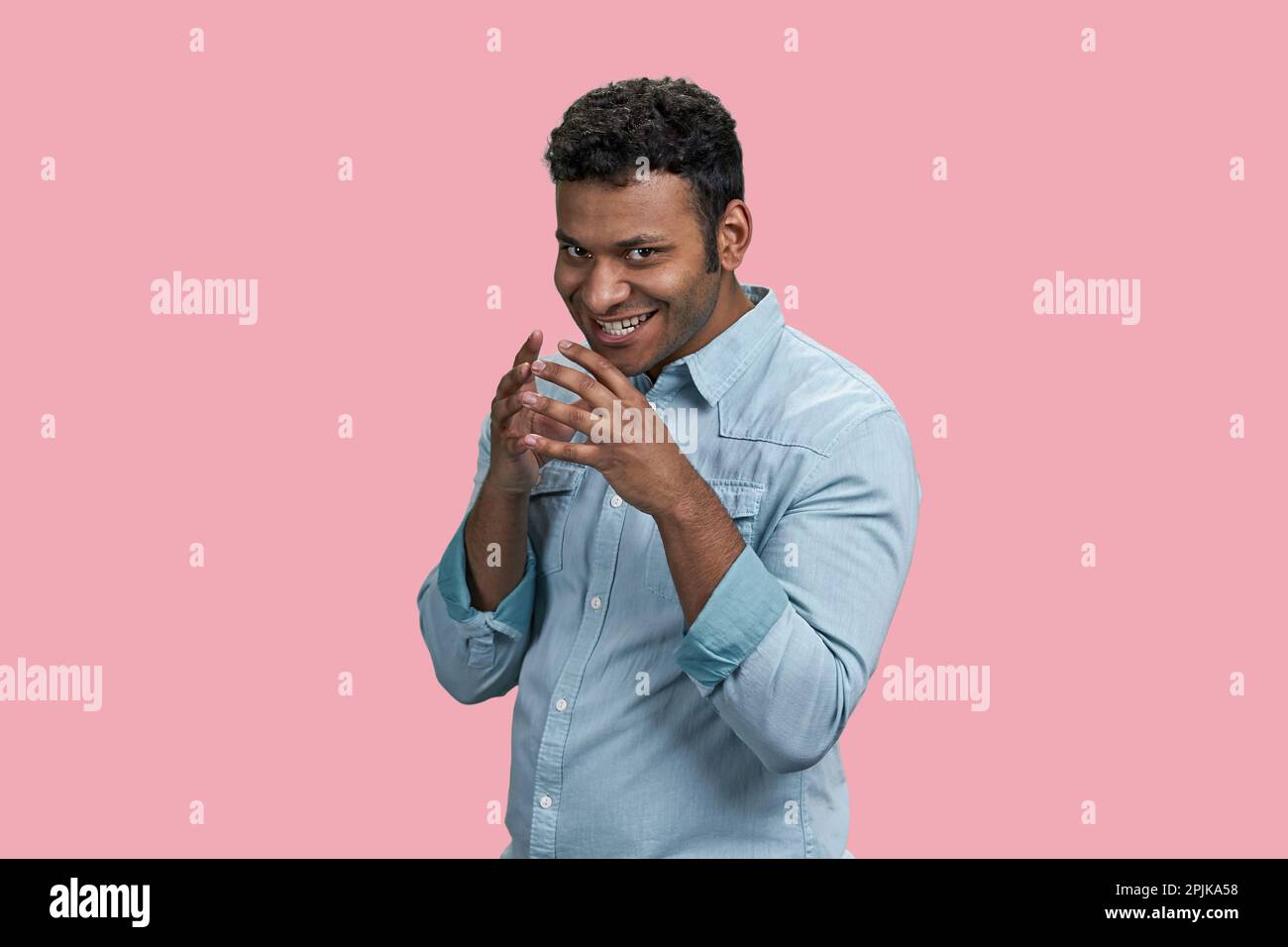 Portrait of a young devious brunette indian man. Cunning tricky face ...