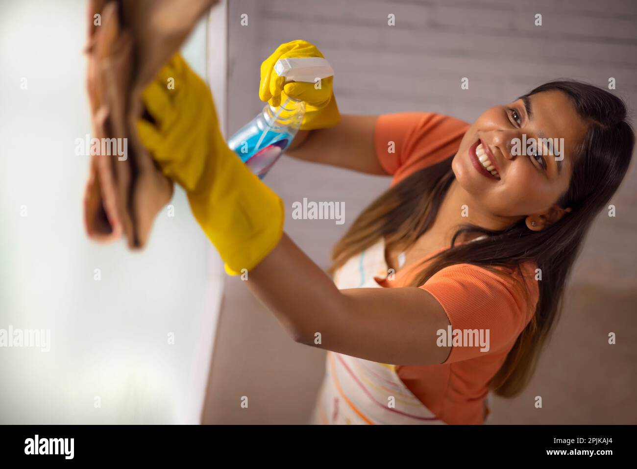Woman cleaning the window of living room at home Stock Photo - Alamy