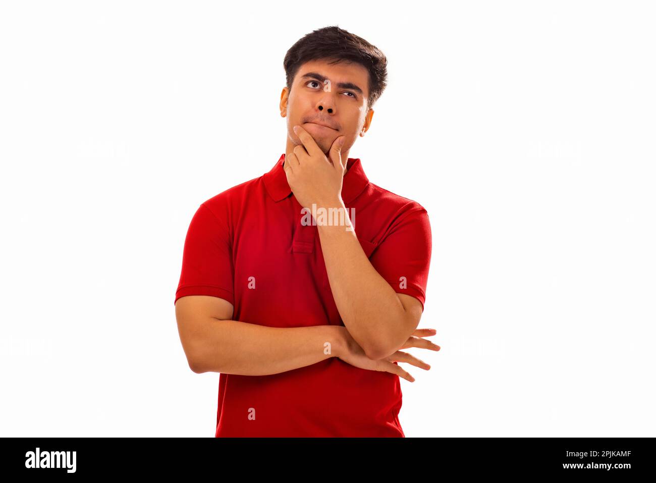 Young man thinking with hand on chin against white background Stock ...