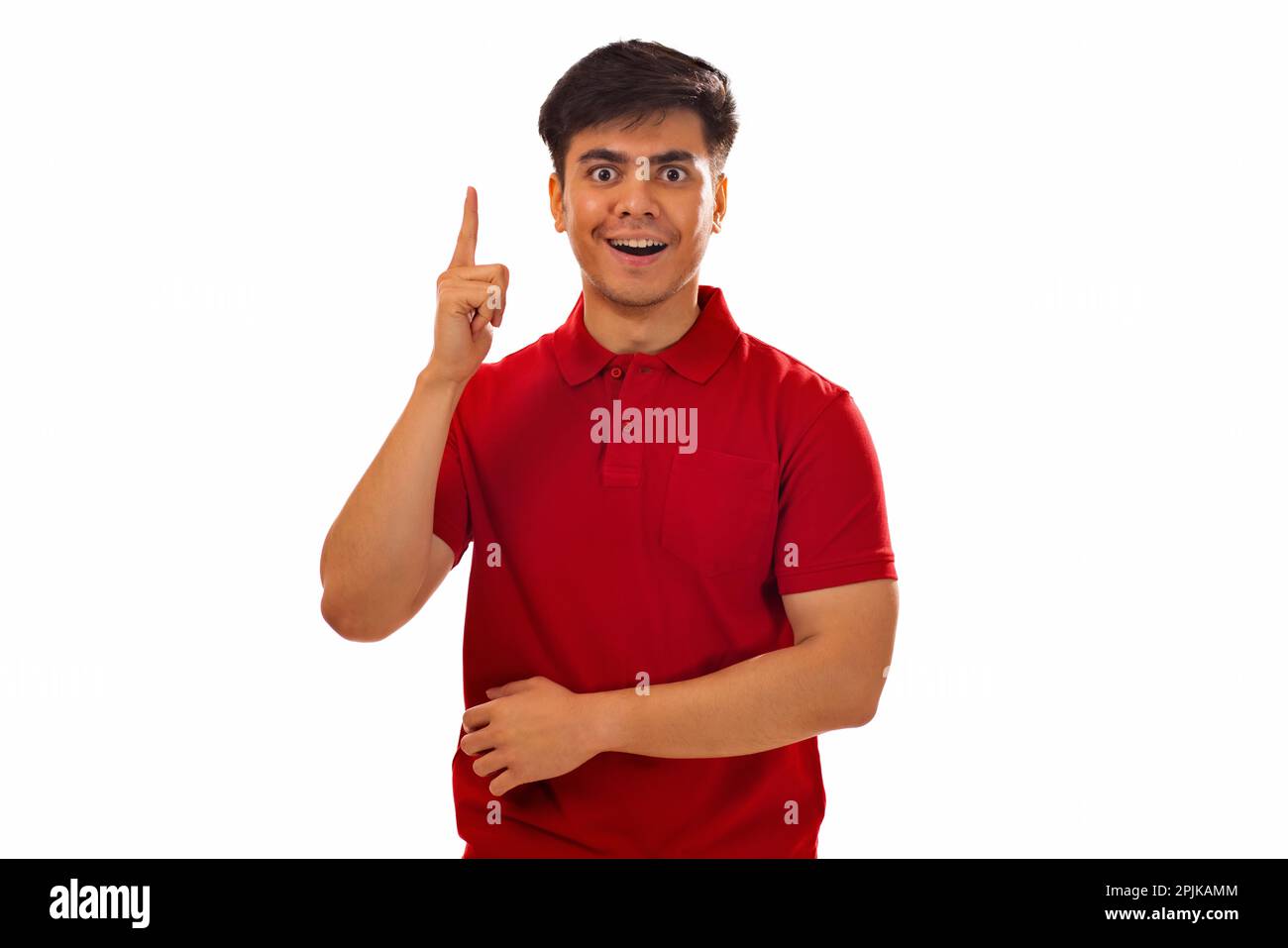 Portrait of young man pointing above camera against white background ...