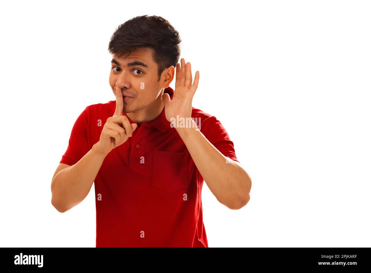 Portrait of young man showing hush gesture against white background ...