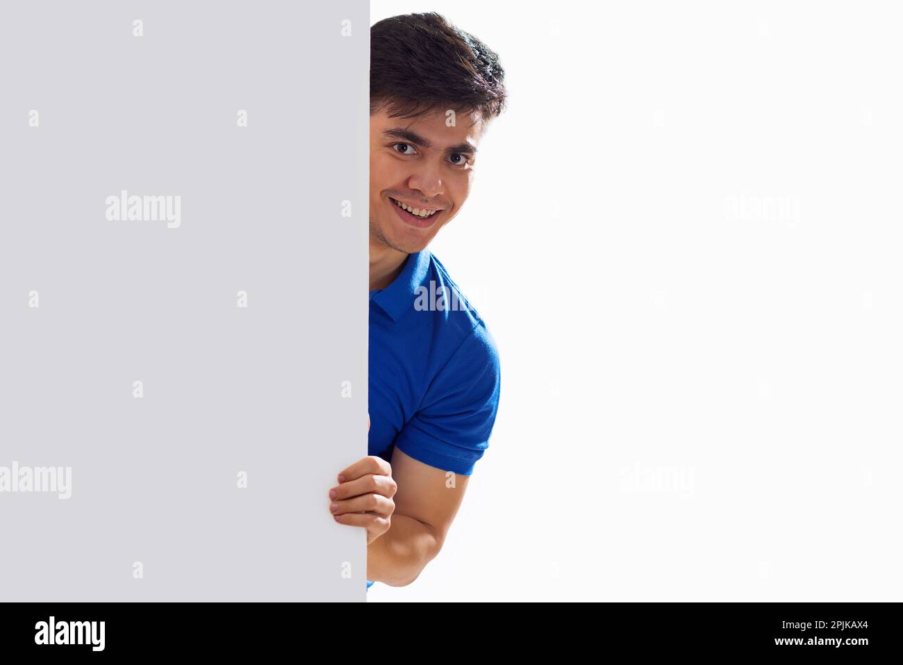 Smiling young man peeking hi-res stock photography and images - Alamy