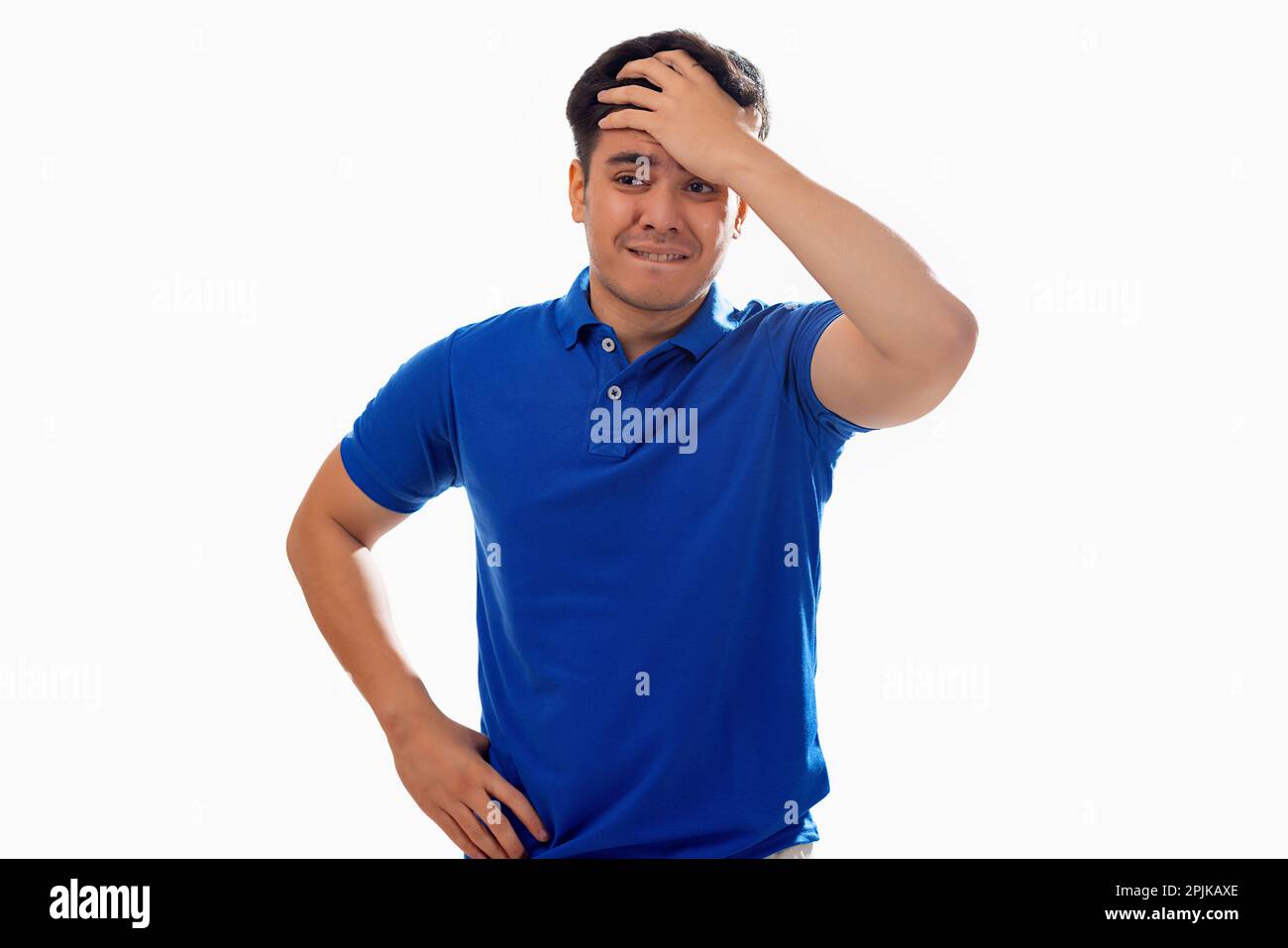 Portrait of disappointed young man with hand on head against white ...