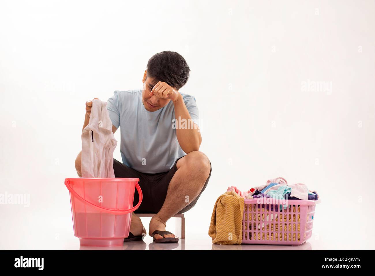 Portrait of young man washing clothes by hand Stock Photo - Alamy