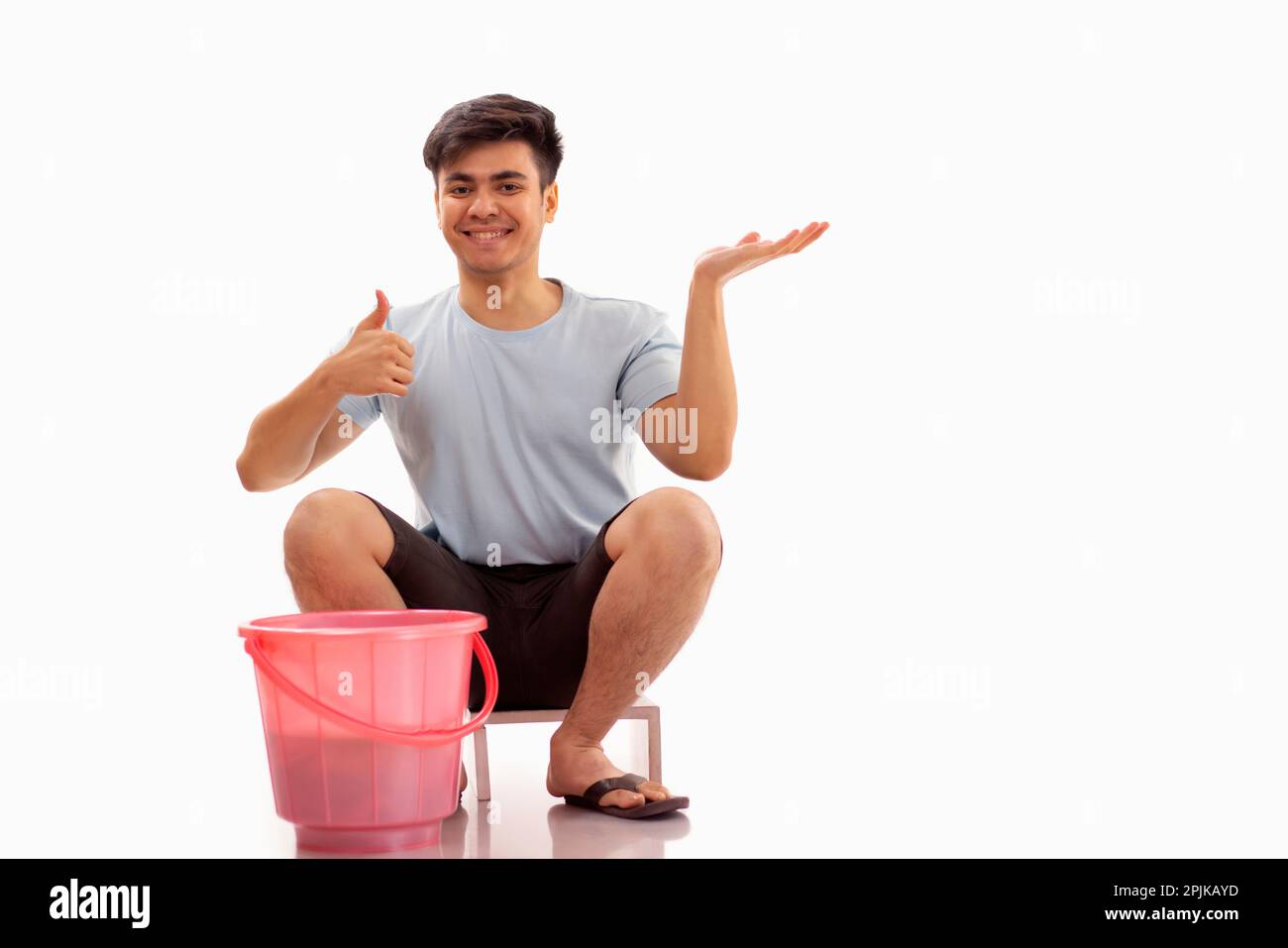 Young man gesturing while washing clothes by hand Stock Photo - Alamy