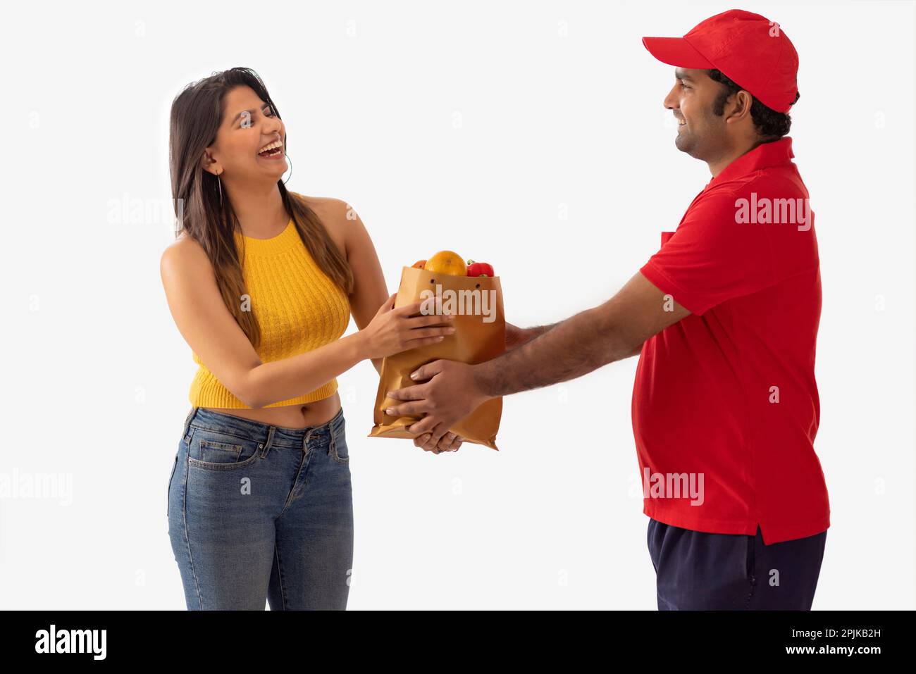 Woman taking delivery of fresh vegetable from delivery boy Stock Photo ...