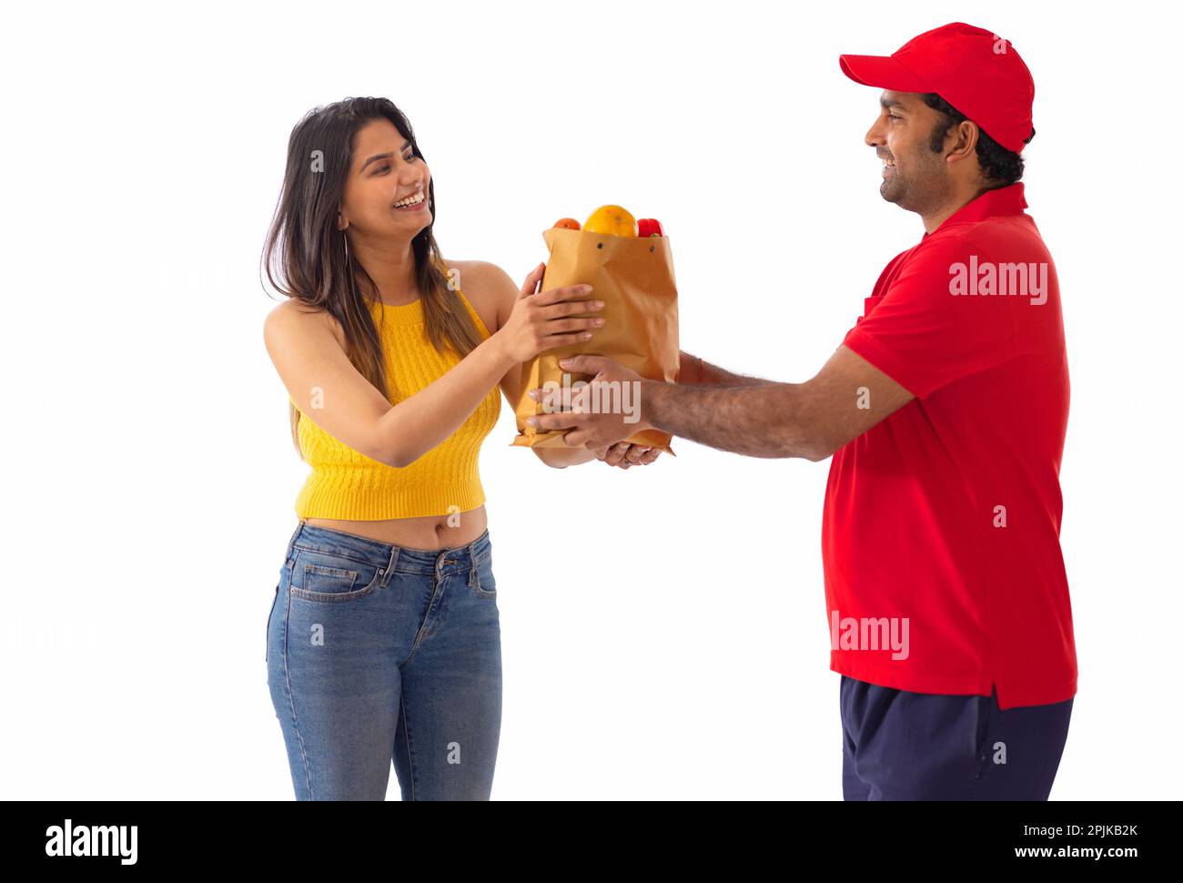 Woman taking delivery of fresh vegetable from delivery boy Stock Photo ...