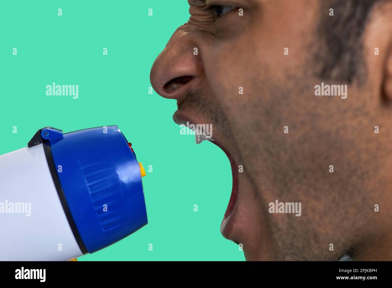 Close up face of indian man screaming in megaphone. Isolated on green ...