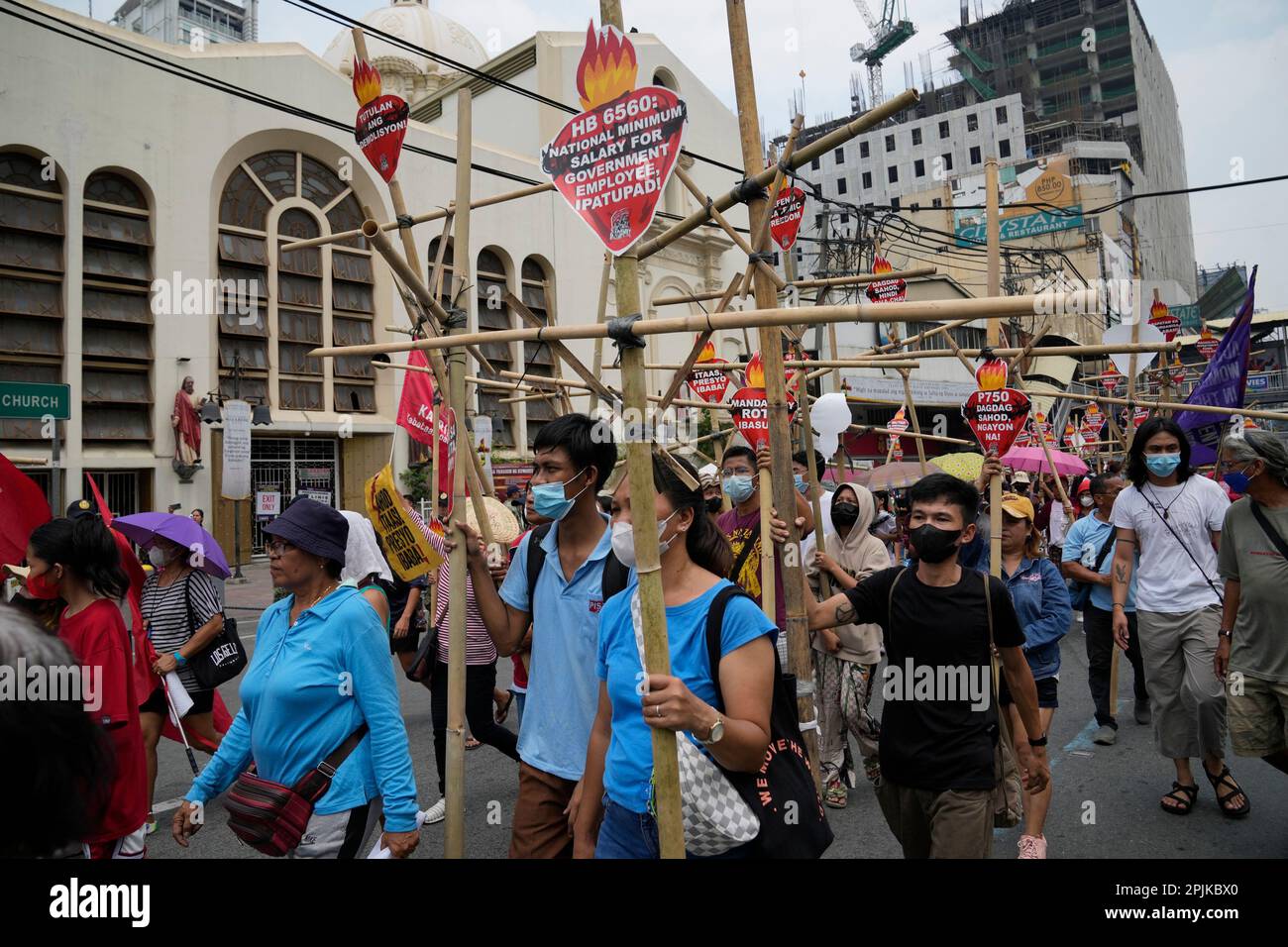 Activists carry crosses bearing slogans as they reenact the sufferings ...