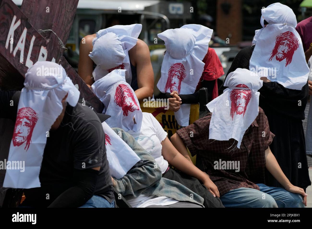 Activists wear clothes bearing the face of Jesus Christ as they reenact ...