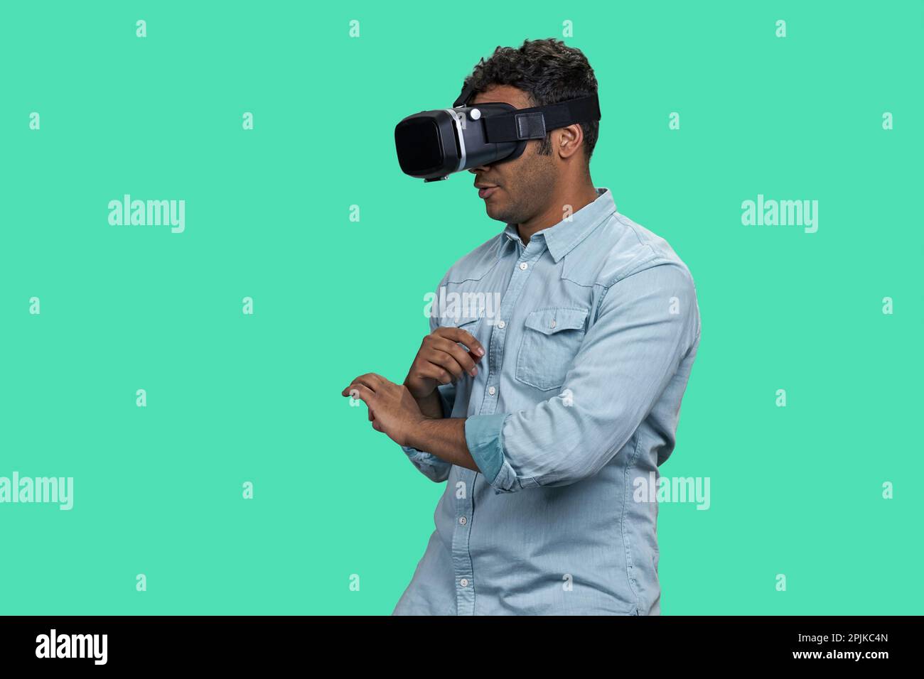 Indian man in vr headset on green background. Young brown southasian ...