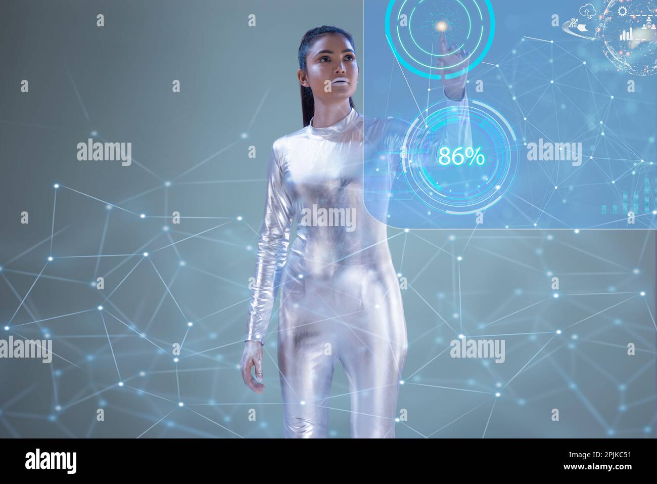 A woman wearing silver dress touching a digital Screen standing on a ...