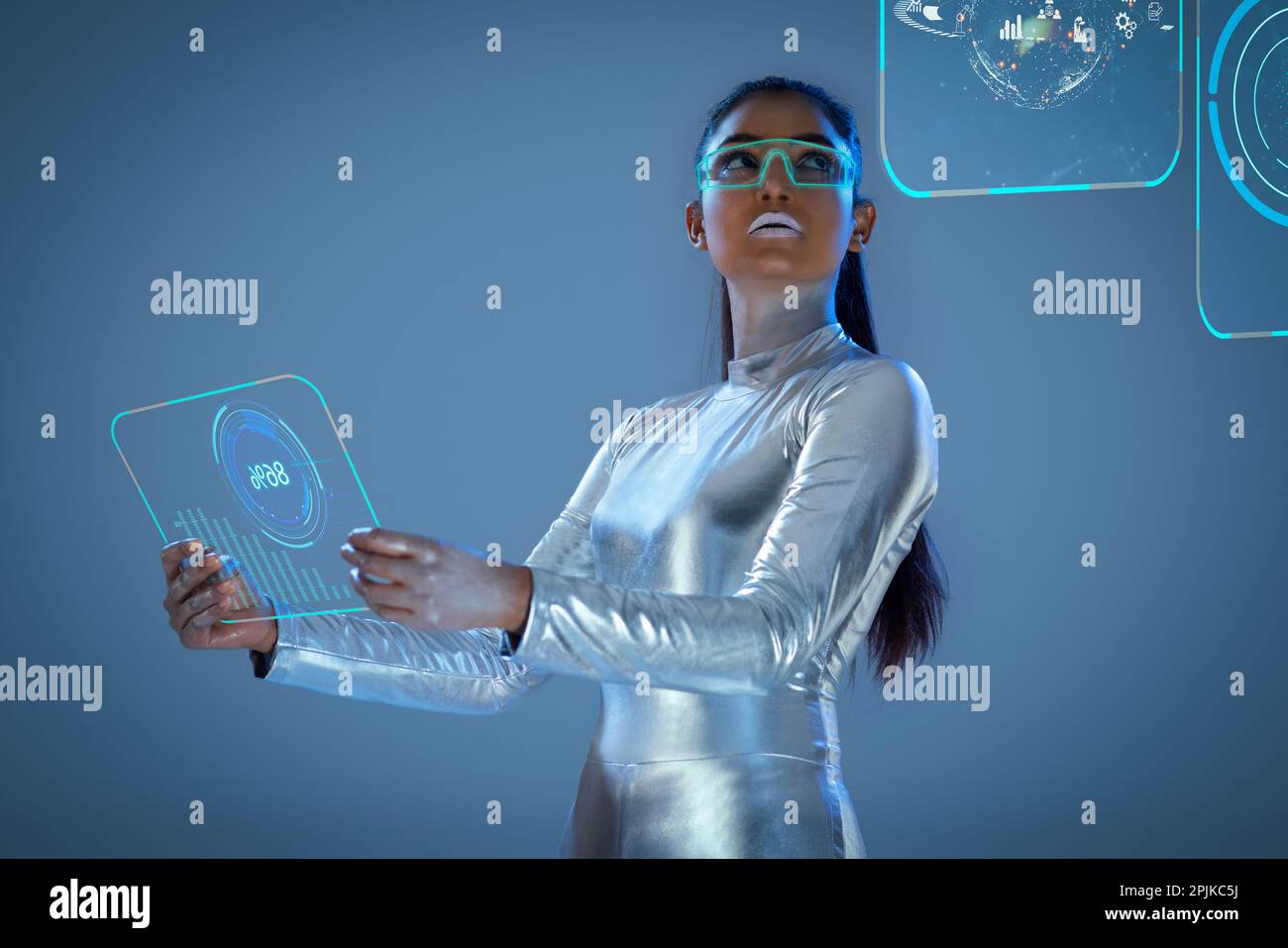 A model dressed as a robot wearing silver, futuristic clothes holding a ...